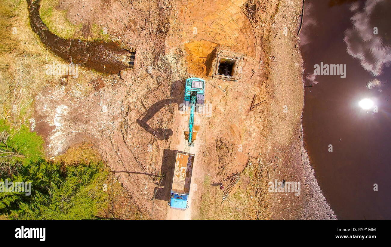 Aerial view of the truck and the backhoe the dumptruck getting close to ...