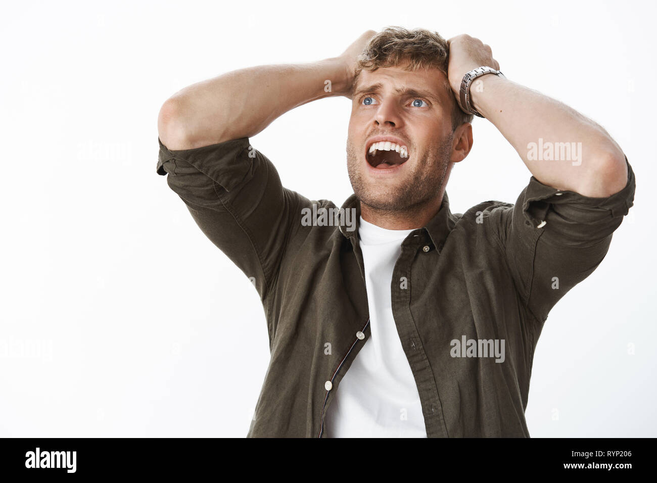 Oh god what do. Anxious handsome blond man holding hands on head in ...