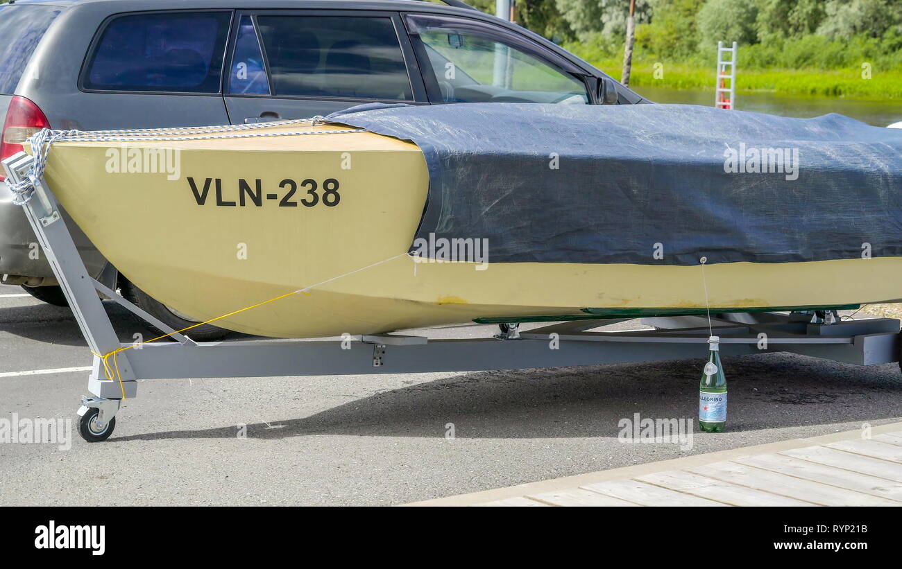 A boat on a trolley in the parking area covered with big cloth beside a ...