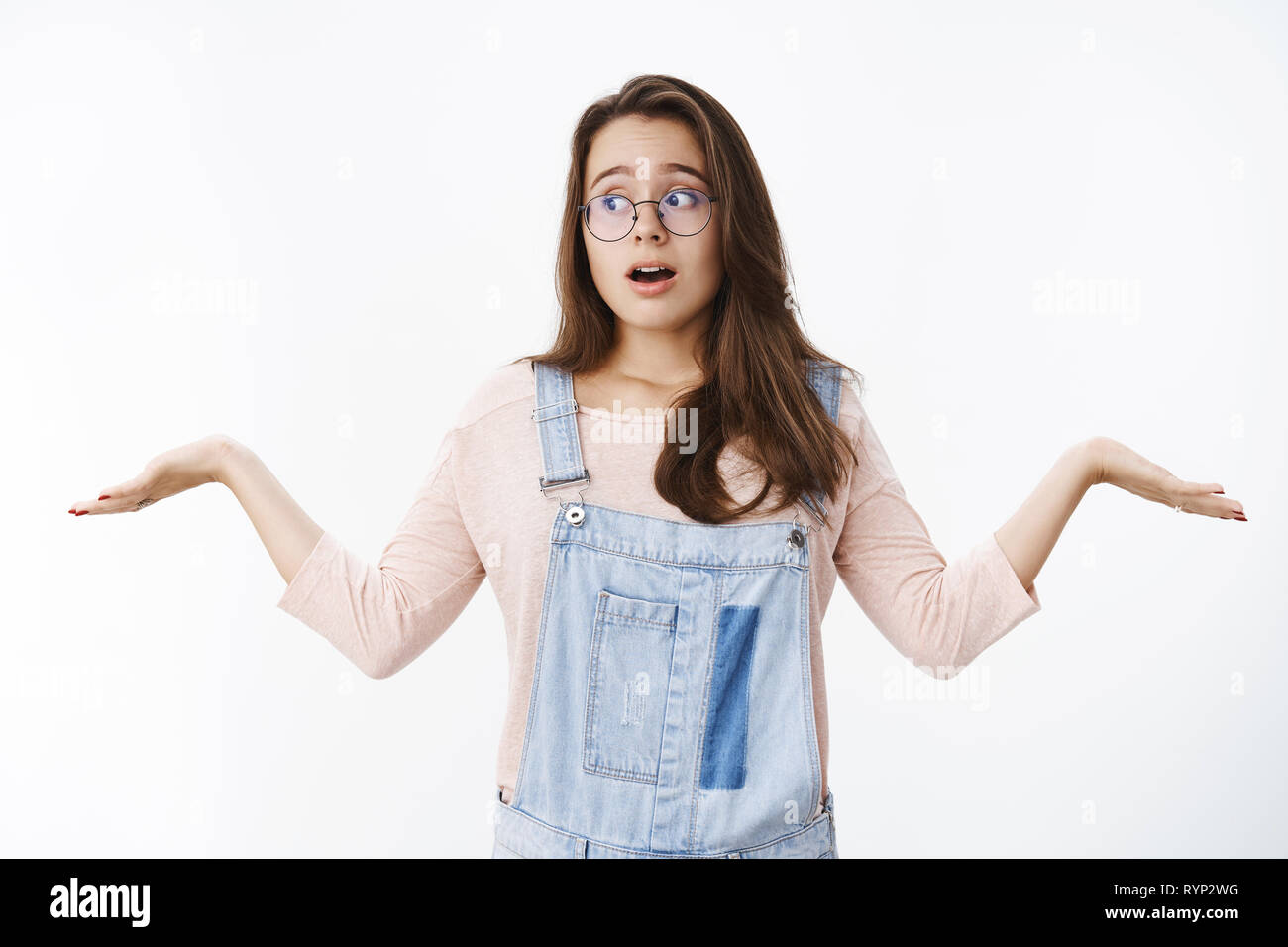 Clumsy and awkward silly young woman in glasses acting unaware and ...