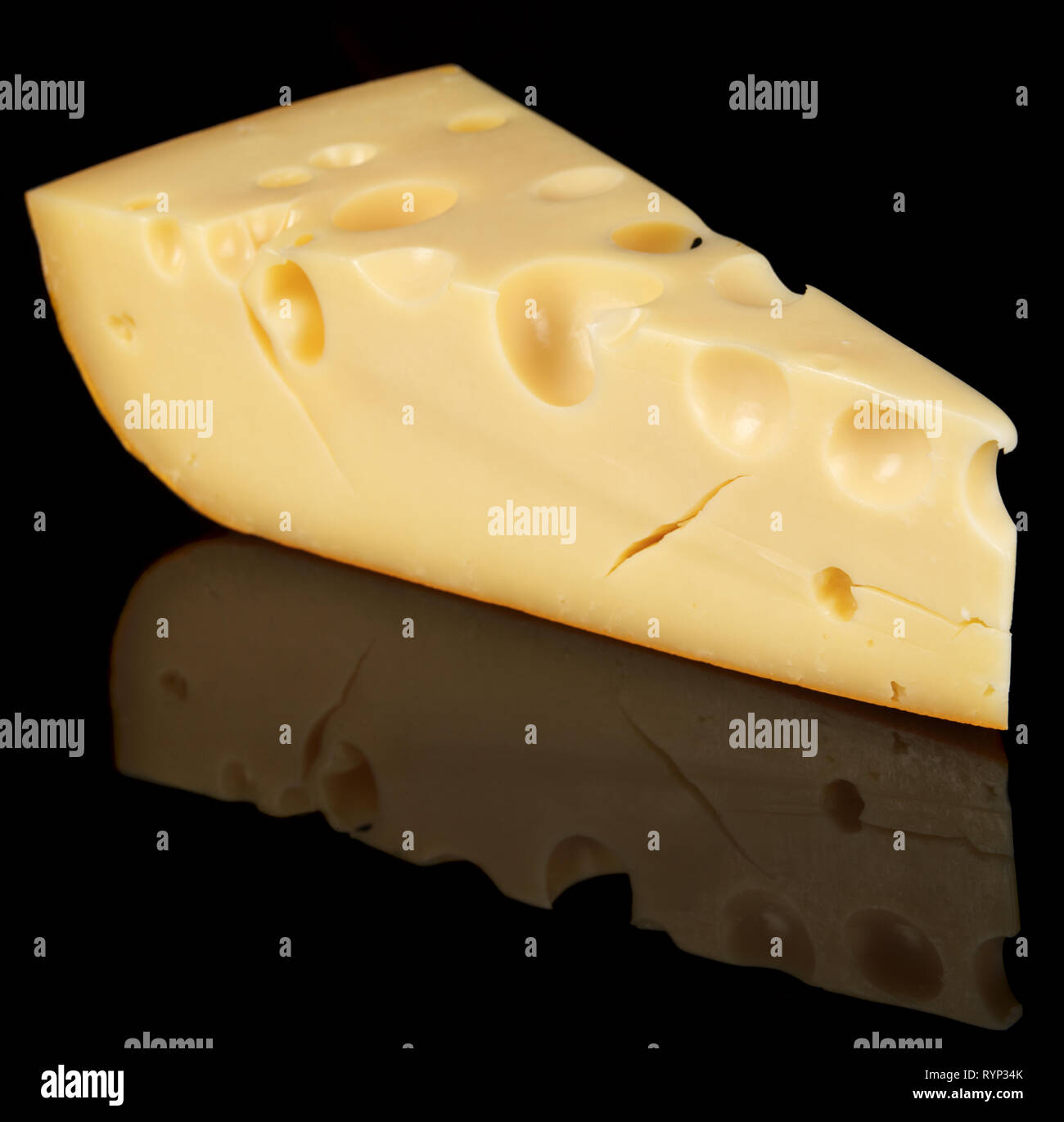 Piece of ripened swiss cheese isolated on black with reflection Stock ...