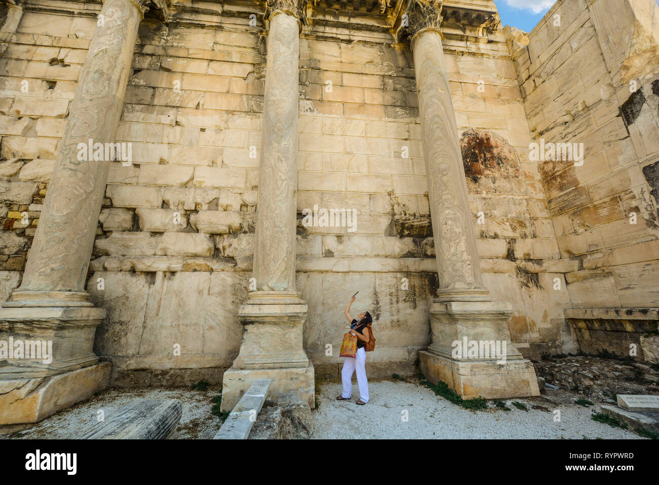 A young woman aims her camera at the ancient Hadrian's Library wall in ...