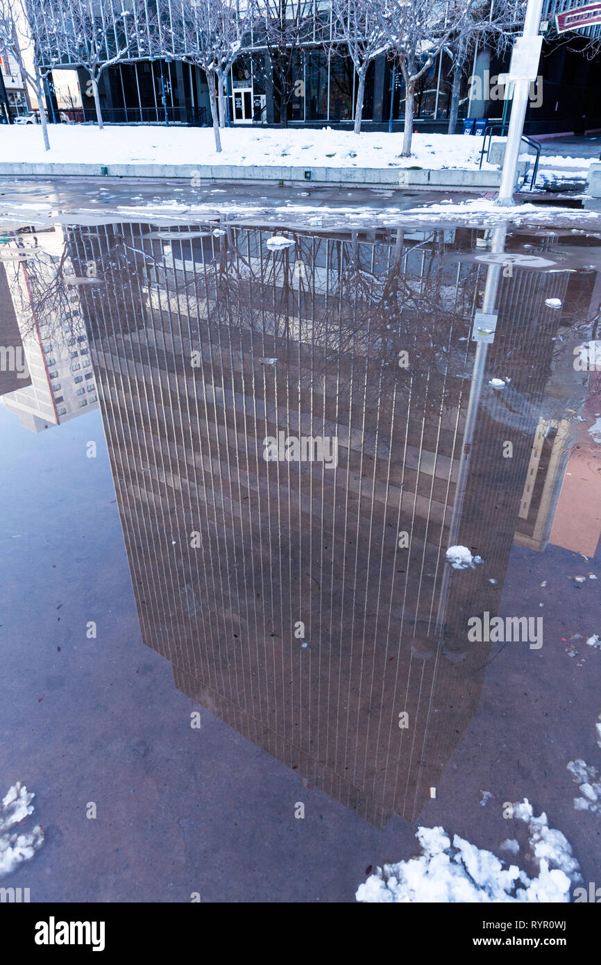 Reflection of office buildings in a puddle on the ground Stock Photo ...