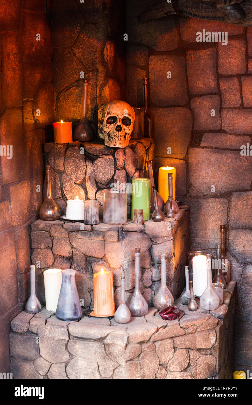 Medieval arrangement of potions, skull and candles in a dark corner ...