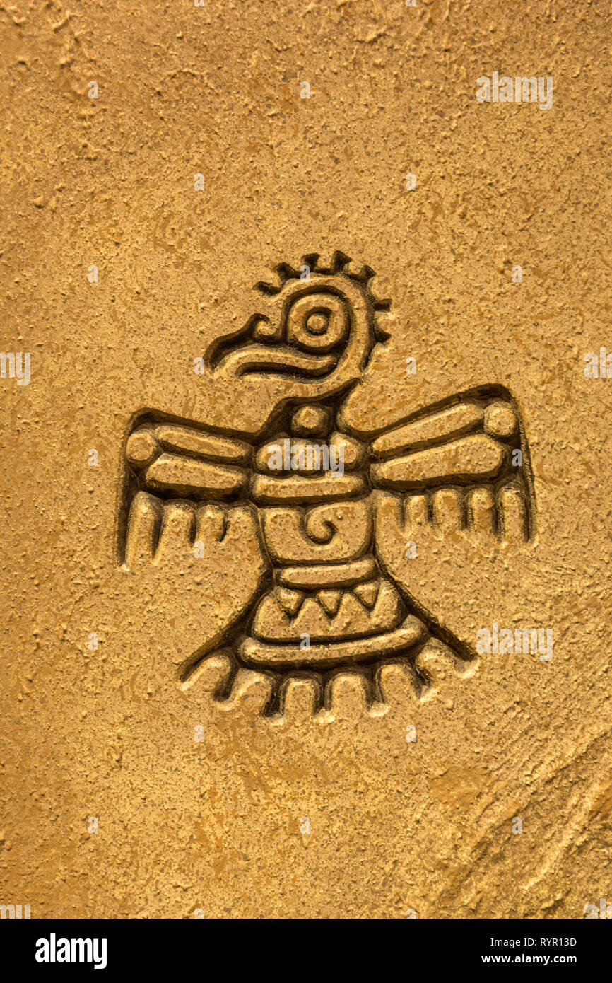 Aztec tribal bird figure carved into textured wall Stock Photo - Alamy