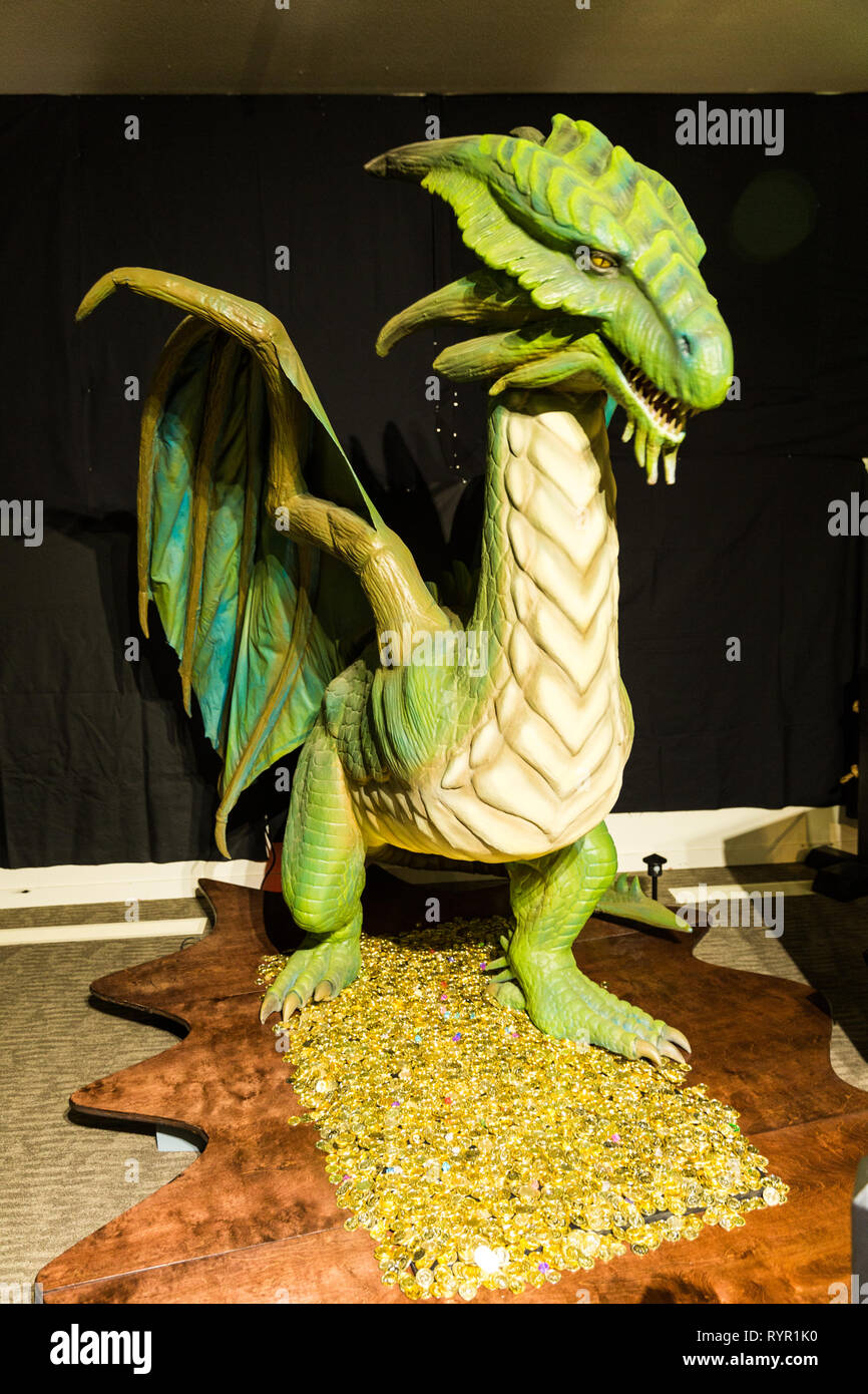 Large green dragon animatronic sitting on a pile of gold coins Stock ...