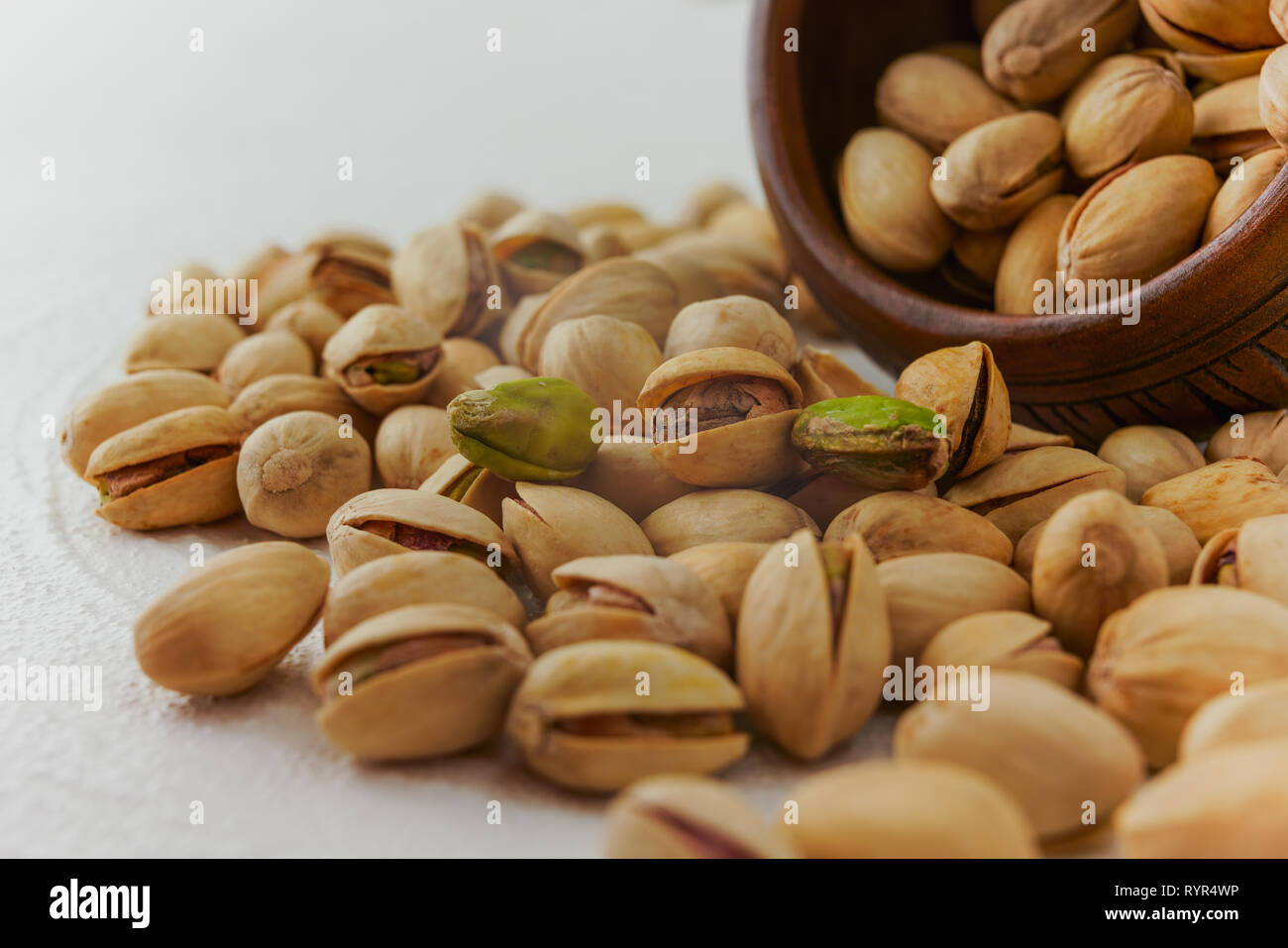 Pistachios on a kitchen table close up, white background Stock Photo ...
