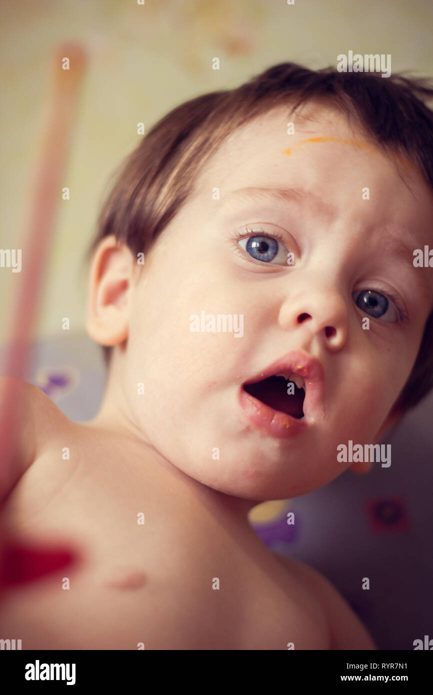 The boy paints on paper. Red and yellow paint. Children's activities ...