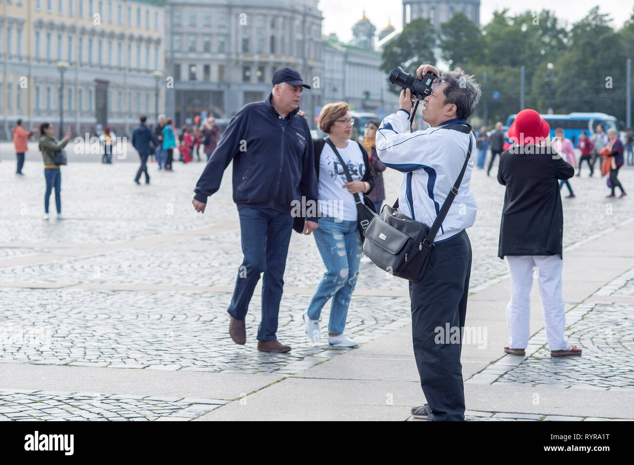 A male tourist of Asian surrounded by other tourists appearance in a ...