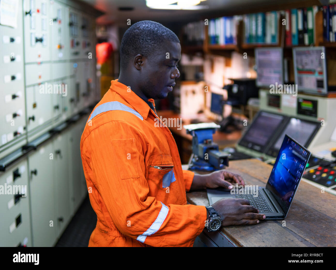 Marine engineer officer working in engine room Stock Photo - Alamy