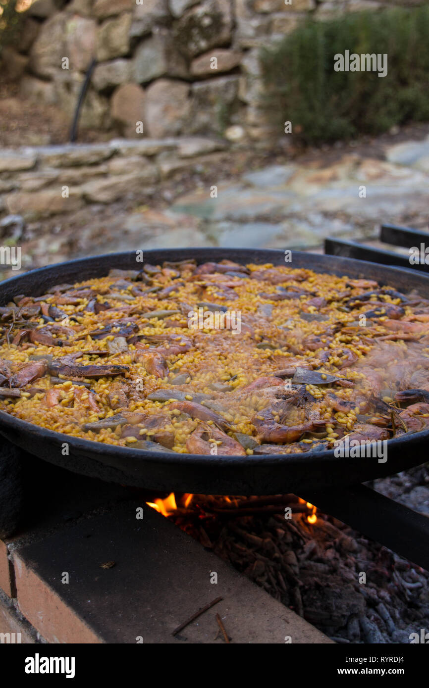 Spanish Paella cooked on natural log fire and coal in traditional ...