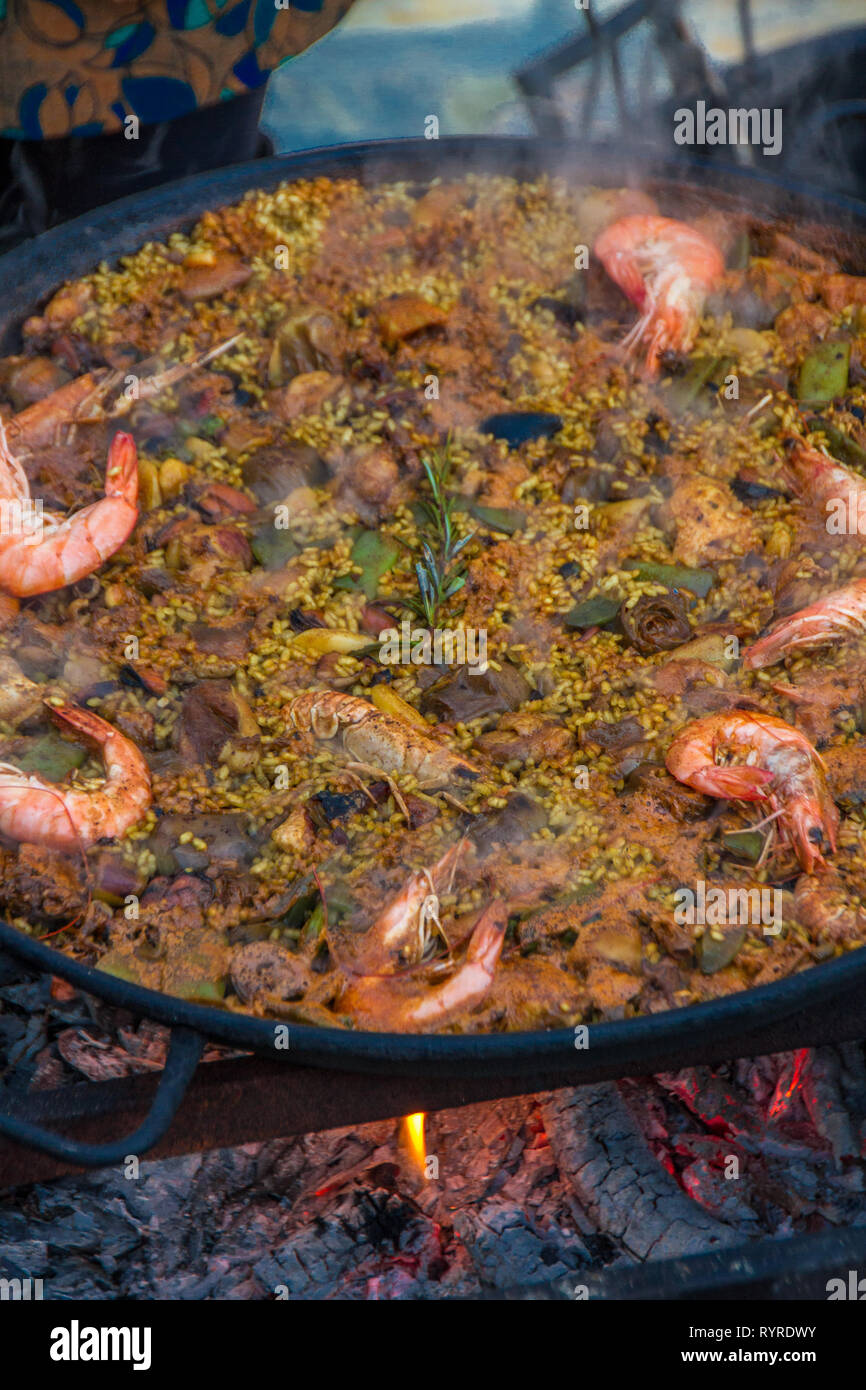 Spanish Paella cooked on natural log fire and coal in a traditional ...