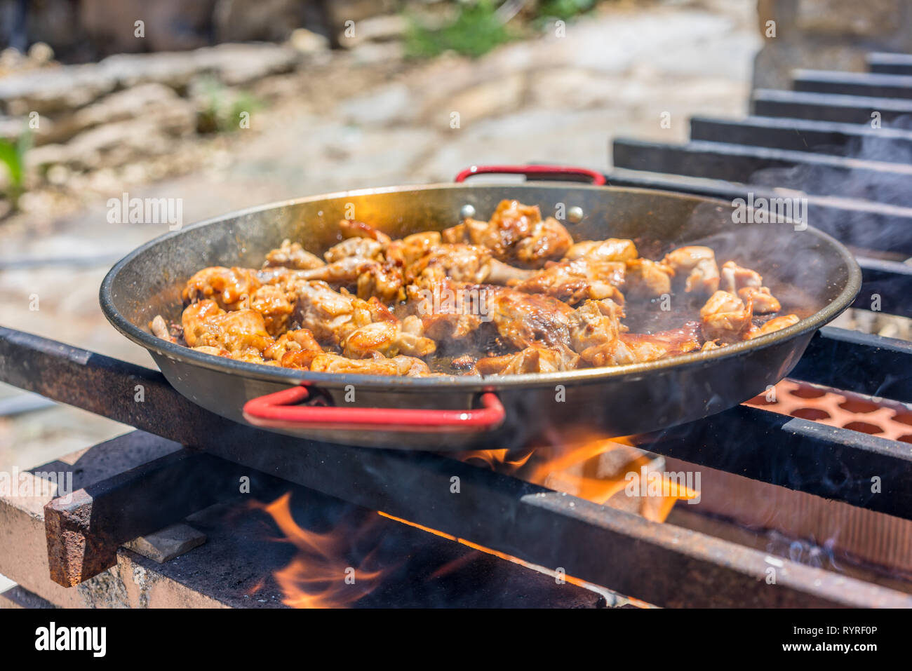 Making spanish traditional valencian Paella stir-frying Rabbit meat ...