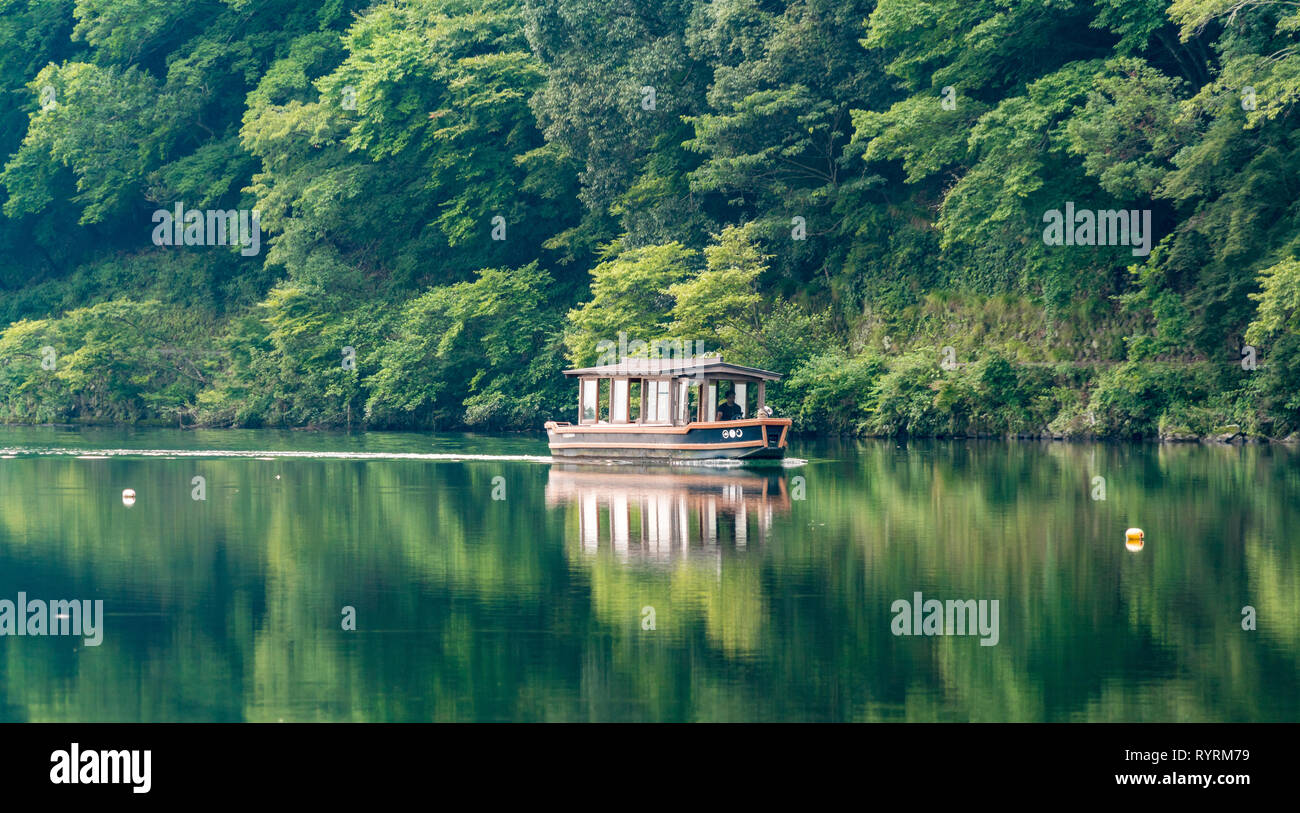 Summer scene: Forest and small ship reflections on the waters of ...