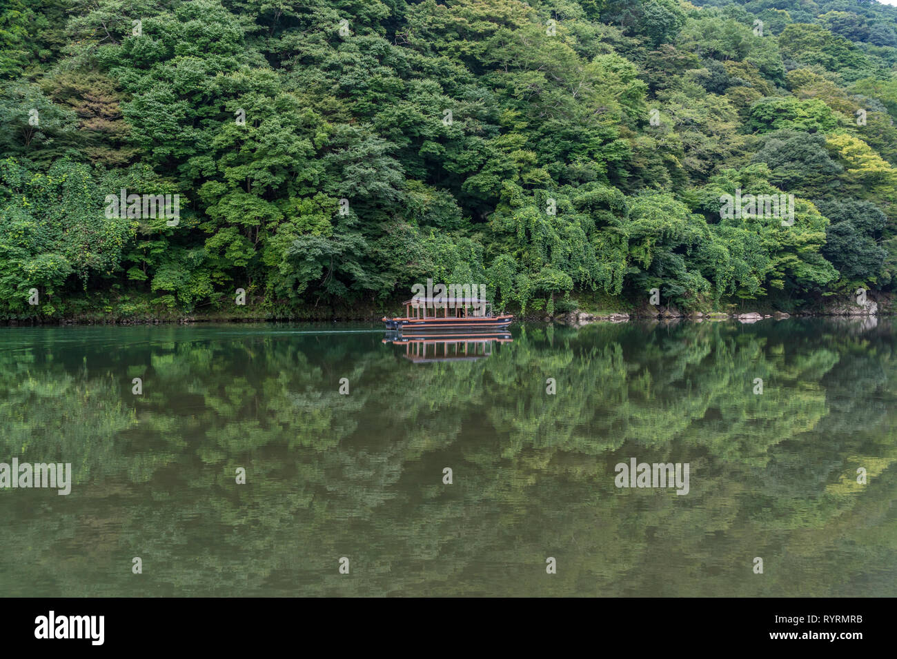Summer scene: Forest and small ship reflections on the waters of ...