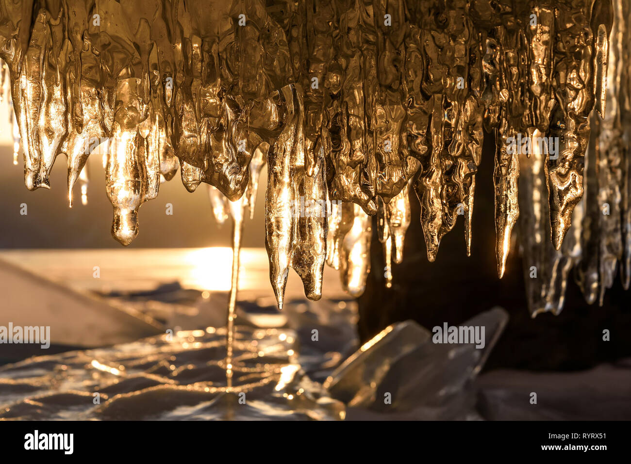 Amazing view with large icicles in orange sunlight against a blurred ...
