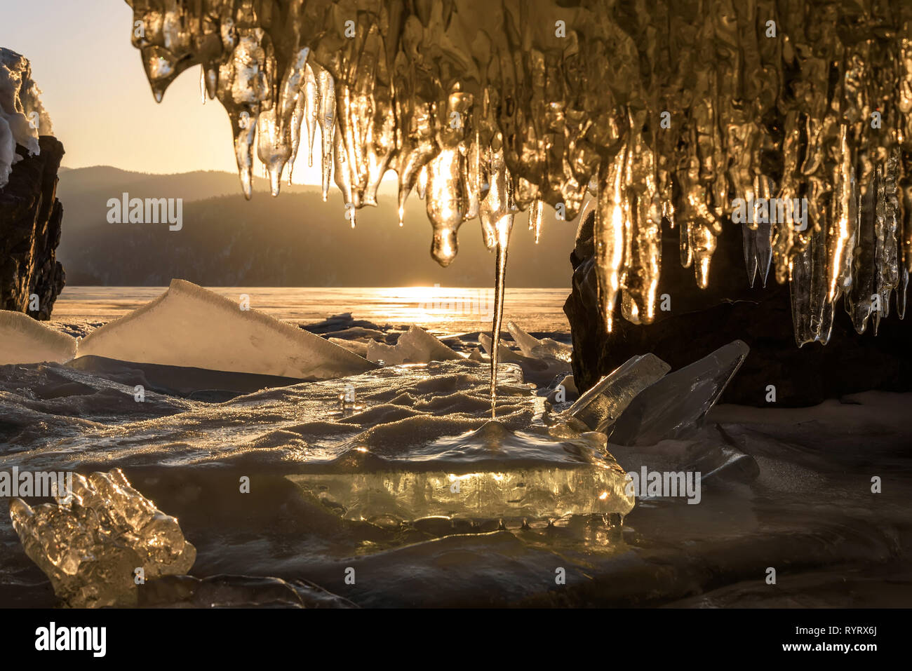 Amazing view with large icicles in orange sunlight against a blurred ...