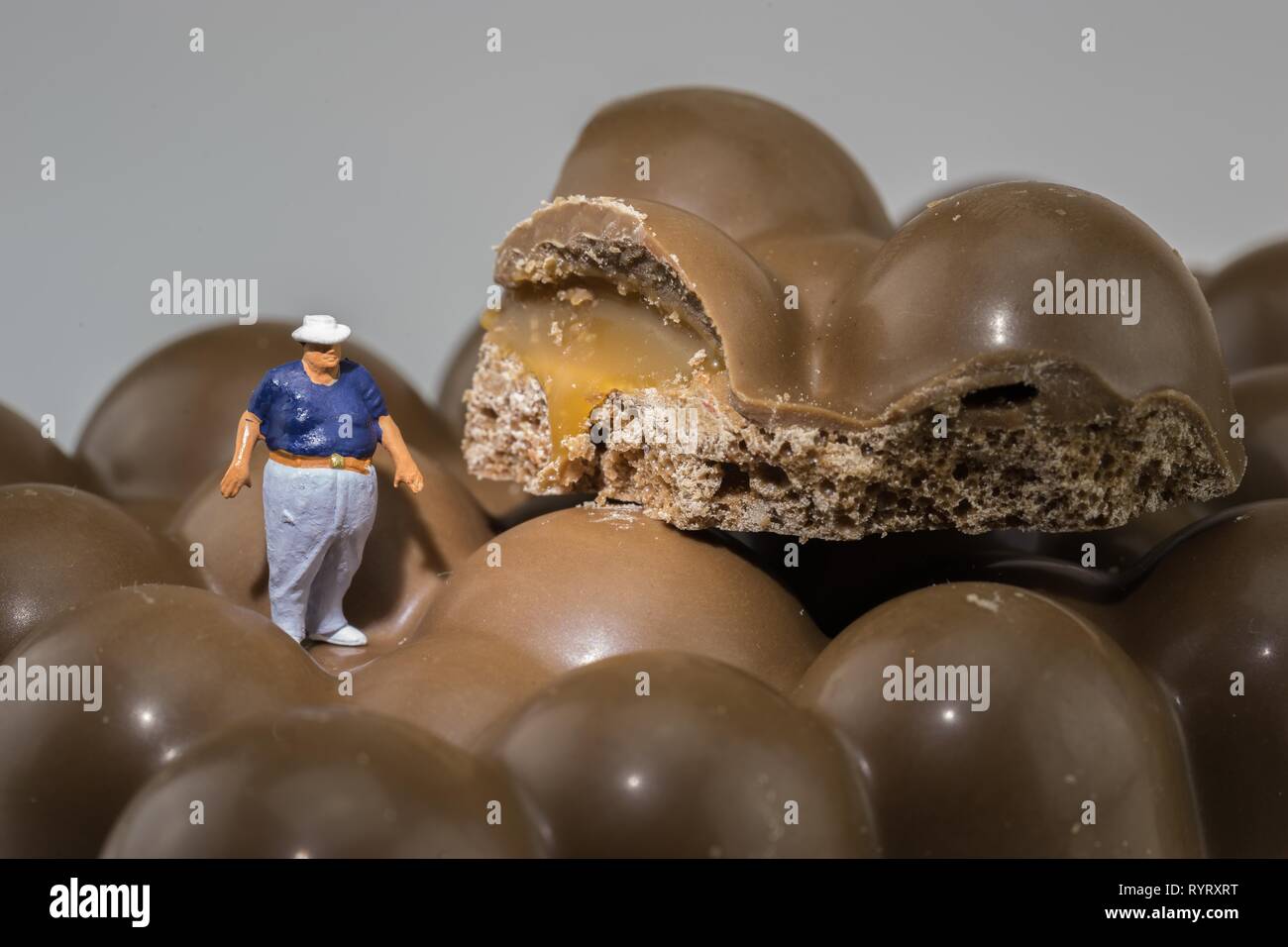 Fat man stands on chocolate, symbolic image overweight by sweets ...