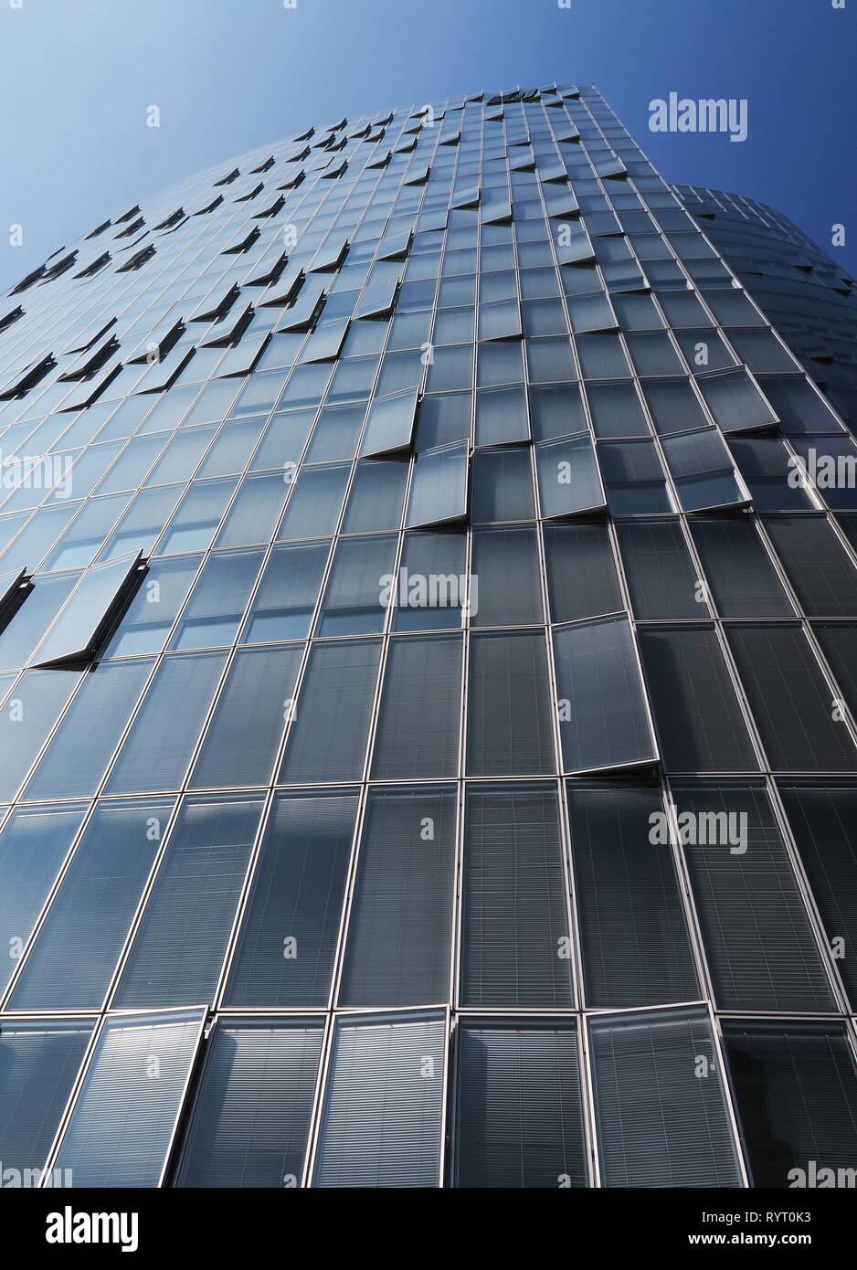 Glass facade with partially opened windows of a high-rise building ...