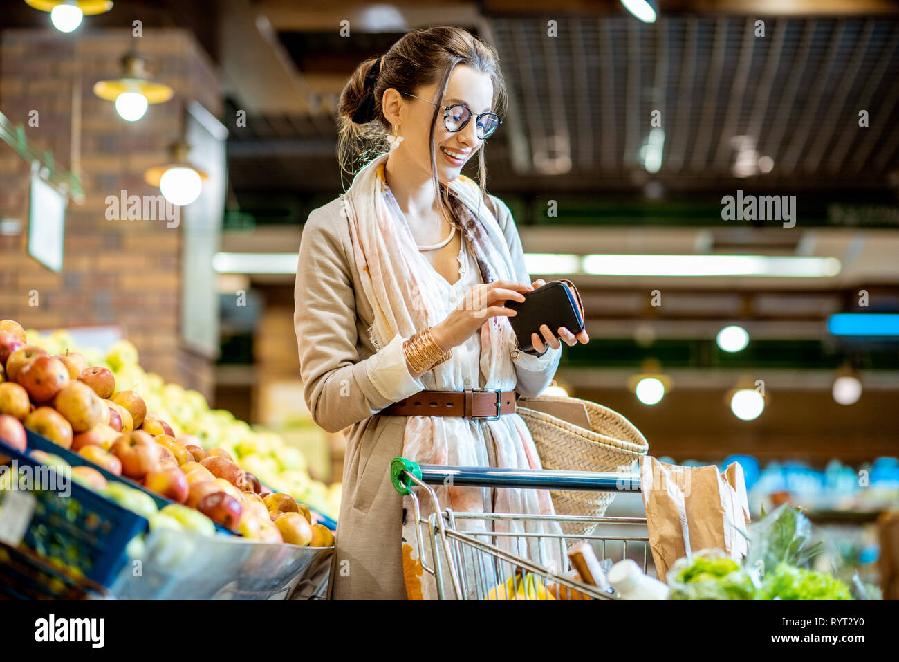 Beautiful young woman shopping for fruits and vegetables in produce ...