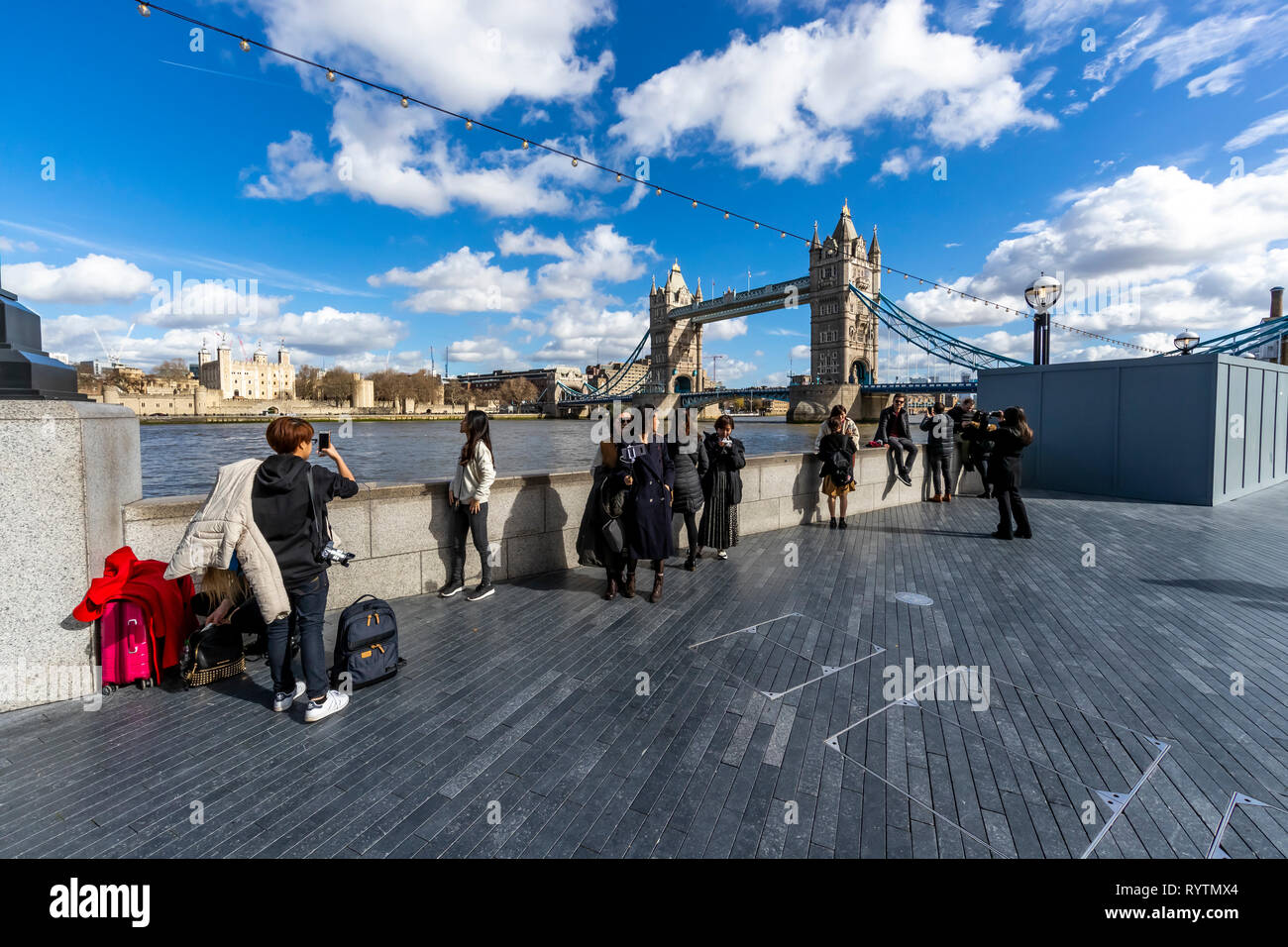 London tourists take pictures and look at Tower Bridge from the Queens ...