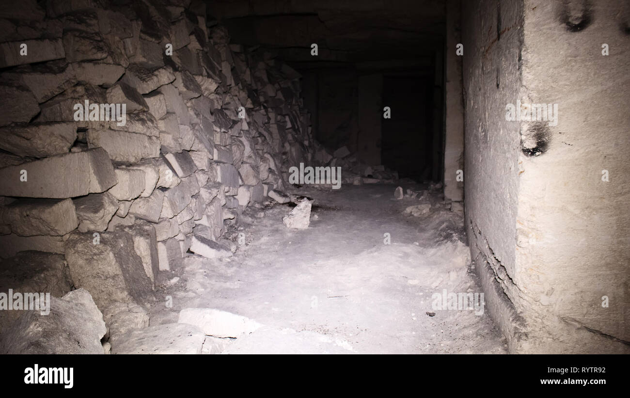 Old underground passage, dungeon, catacombs lined with stones and slabs ...