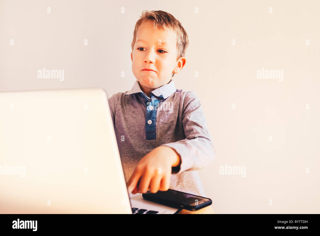 Child working with his computer in his business, concentrated typing to ...