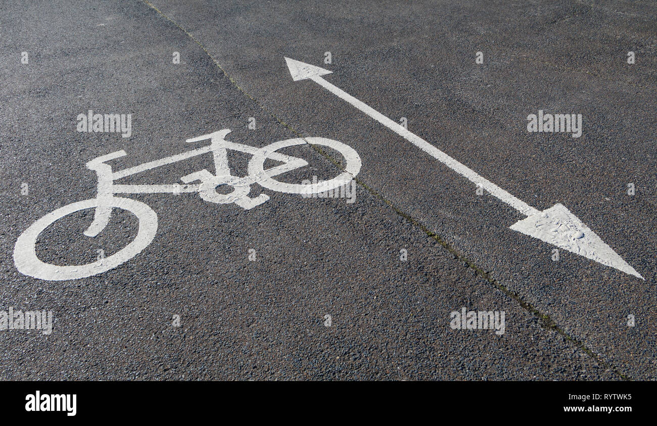 Cycle path indicated by painted white bike on tarmac with arrow ...