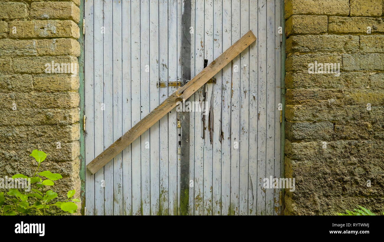 A big door with a big wooden lock put in sideways infront of the wooden ...