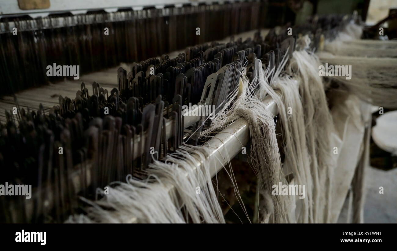 Closer look of the old white threads on the big sewing machine in the ...