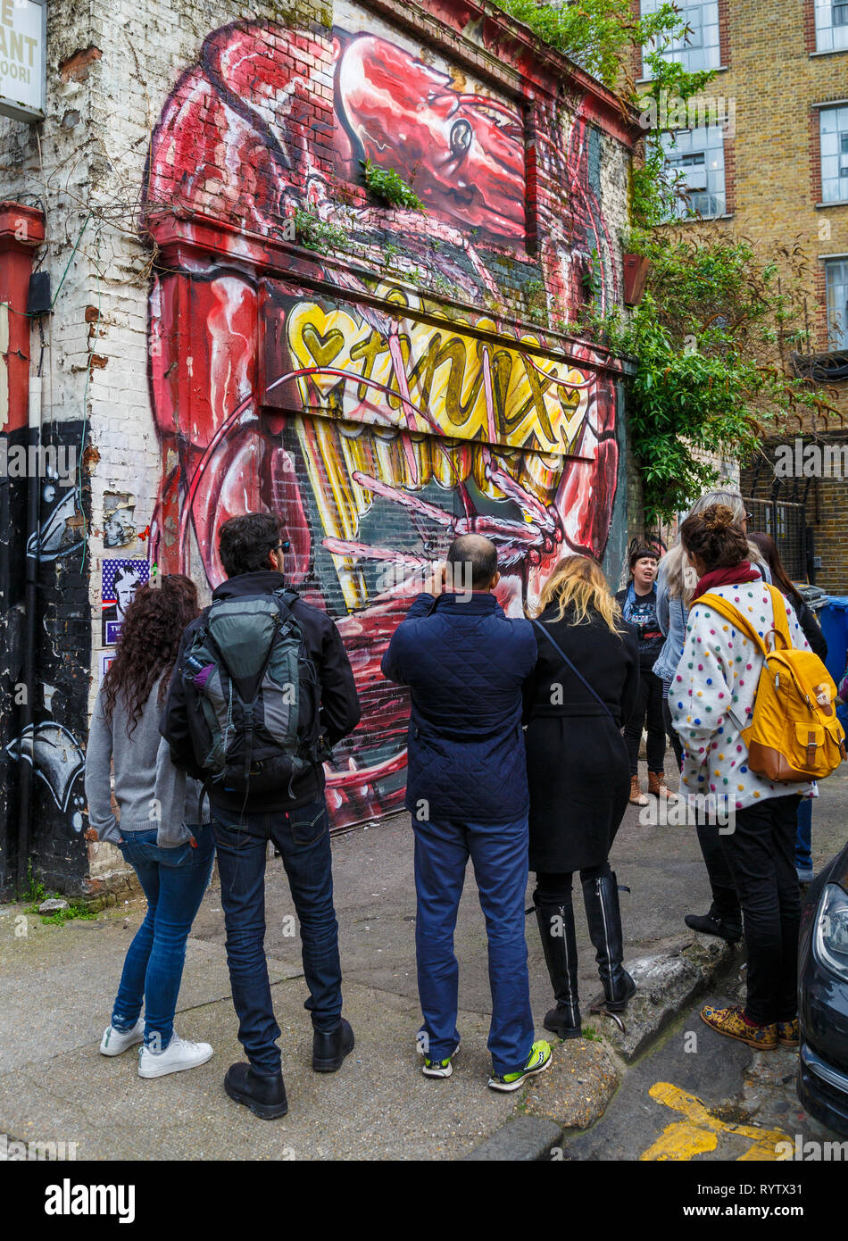 A tour group are shown around the popular graffiti districts of London ...