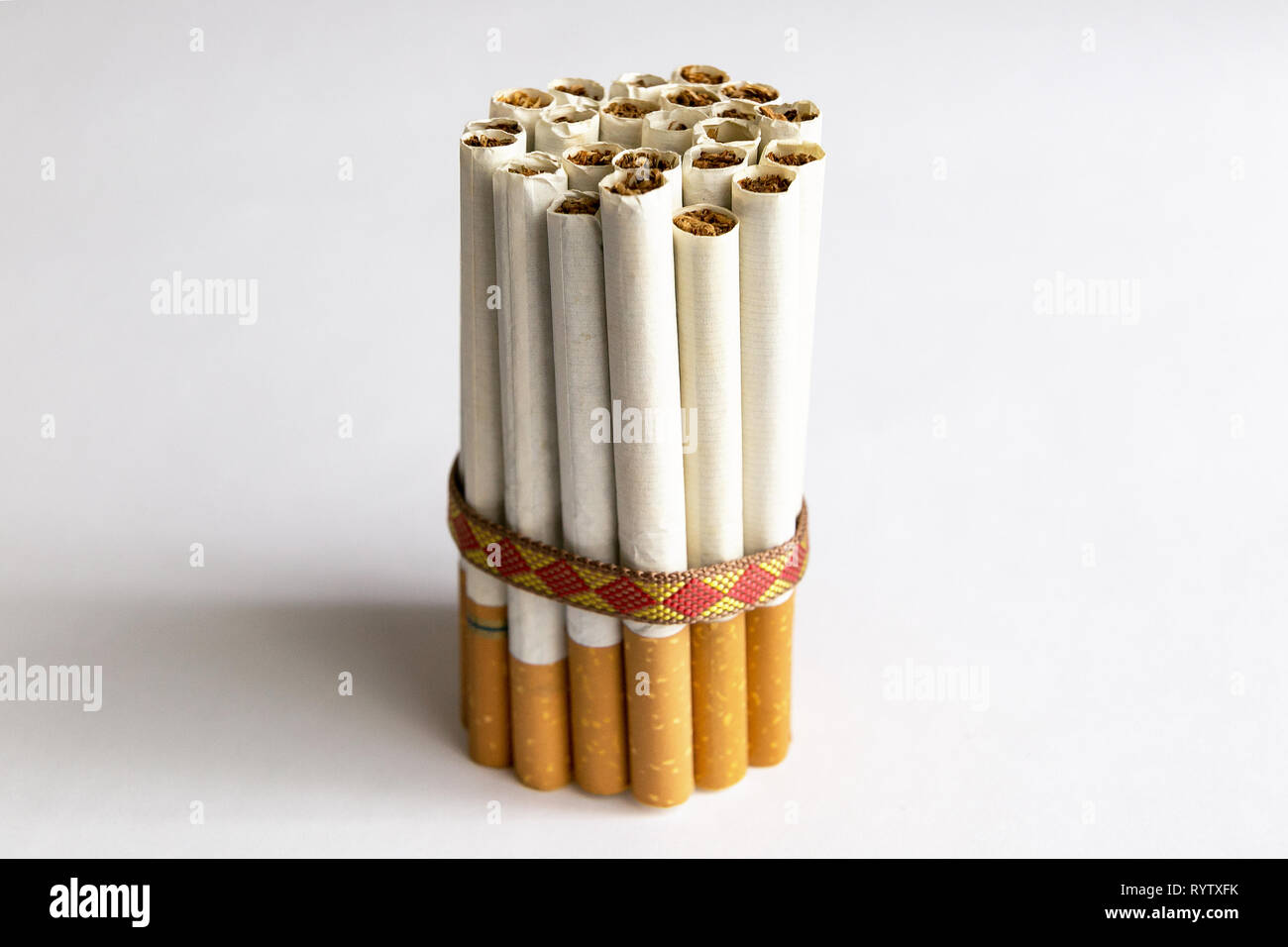 Many tobacco cigarettes tied with a rope on a white background Stock ...