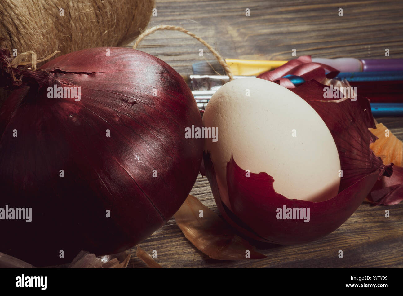 Fresh whole red onion, egg balancing in a dried onion skin and ball of ...