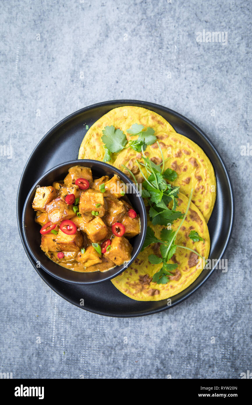 Indian malai paneer decorated with red chillies in a black bowl and 3 ...