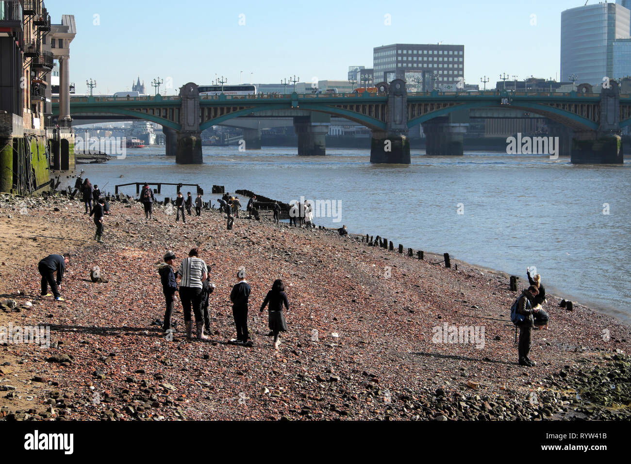 View of River Thames at low tide, school children mud larking looking ...