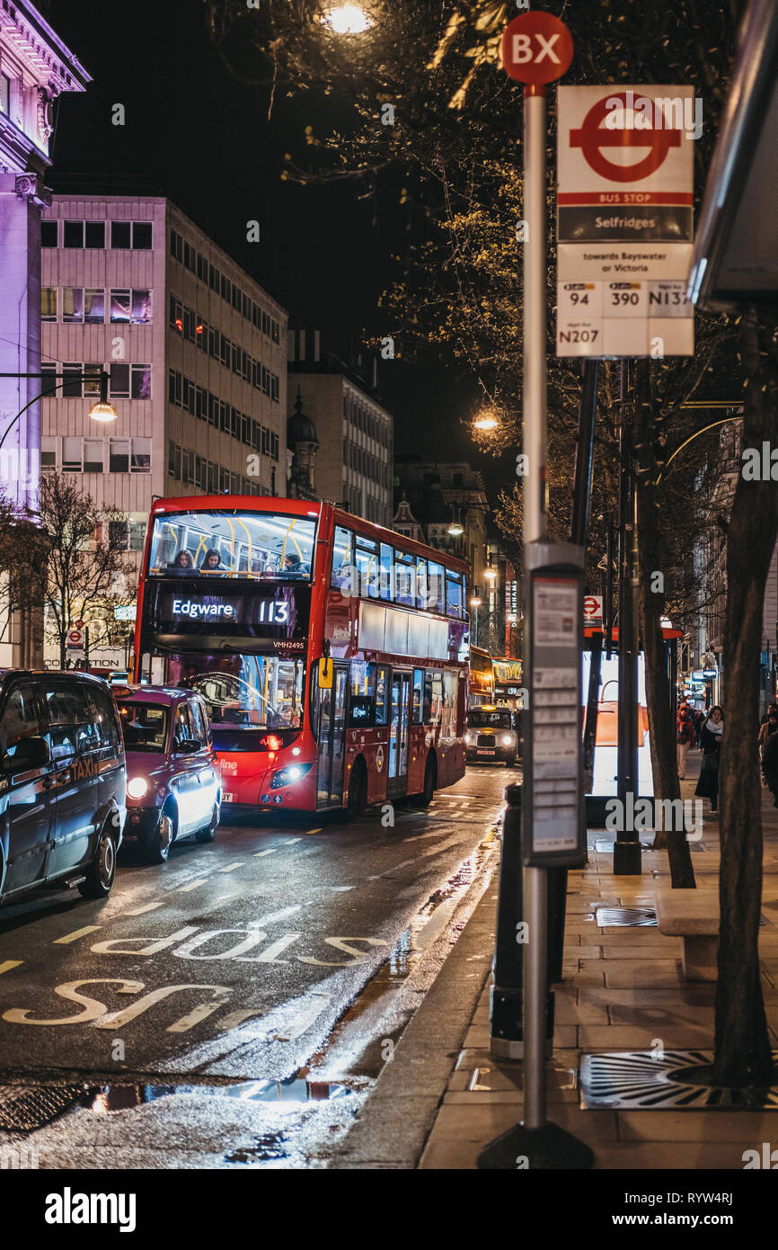 London, UK - March 9, 2019: Red double decker bus approaching bus stop ...