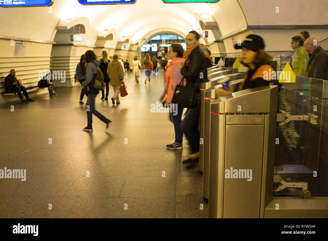 Blur. A crowd of people in a hurry passes through electronic turnstiles ...