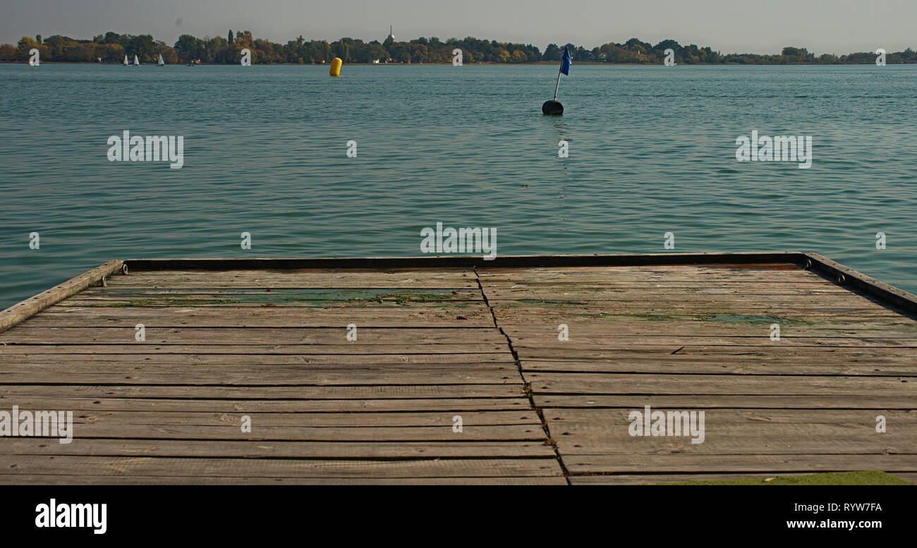 Rustic wooden pier and lake with other shore Stock Photo - Alamy
