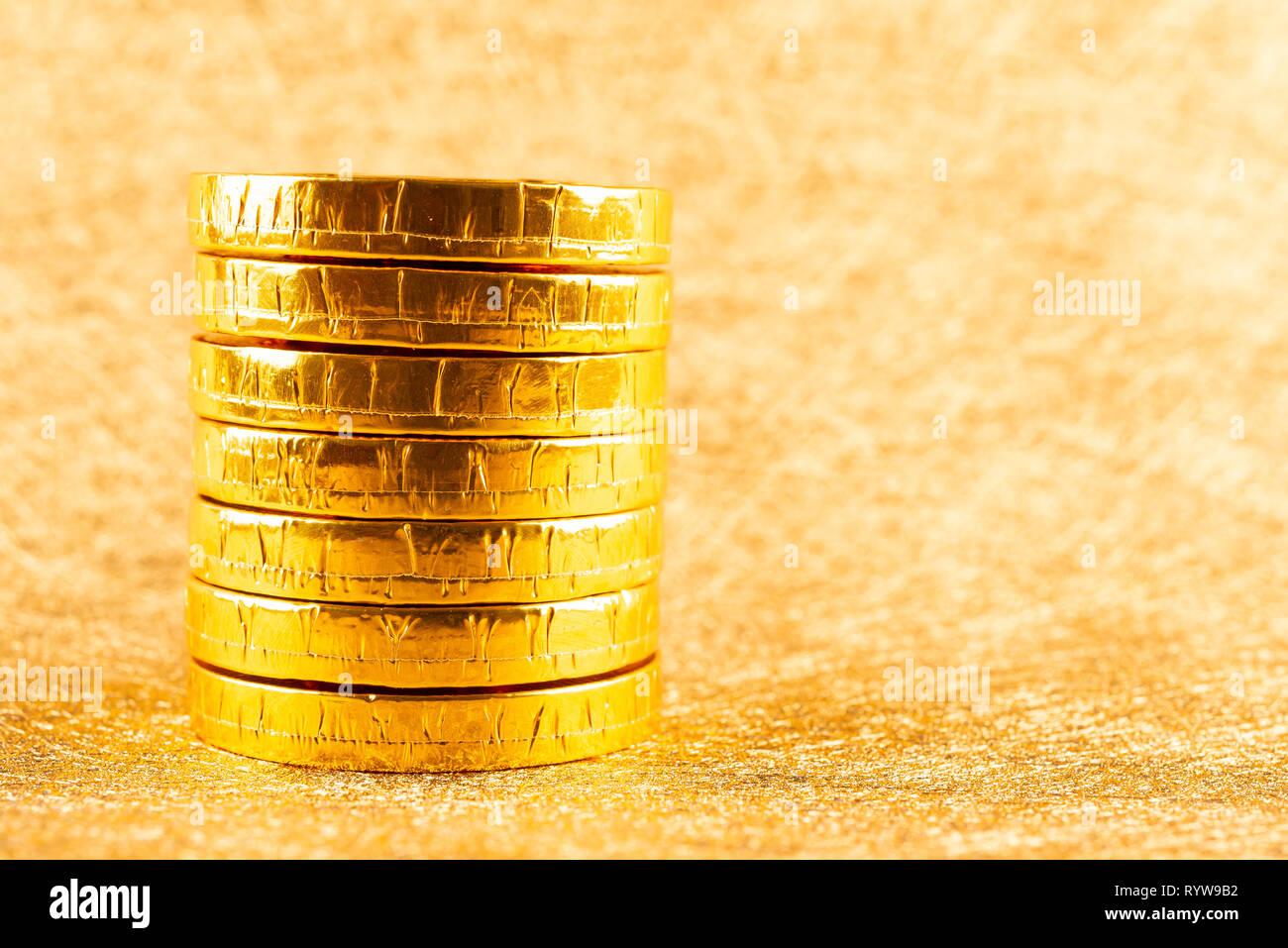 chocolate coins stack up on a golden background Stock Photo - Alamy