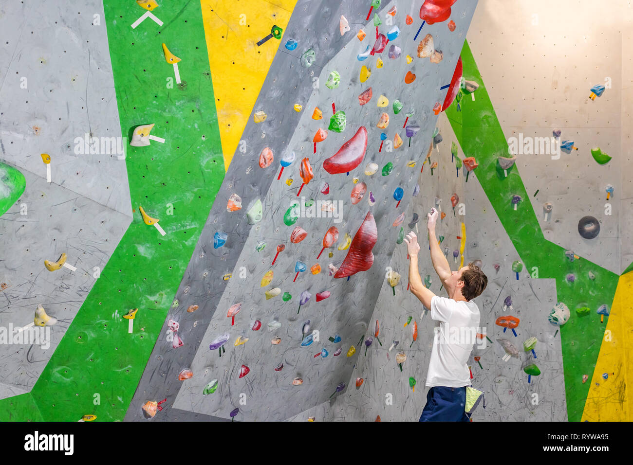 climber explores and develops a route on a climbing wall in the boulder ...