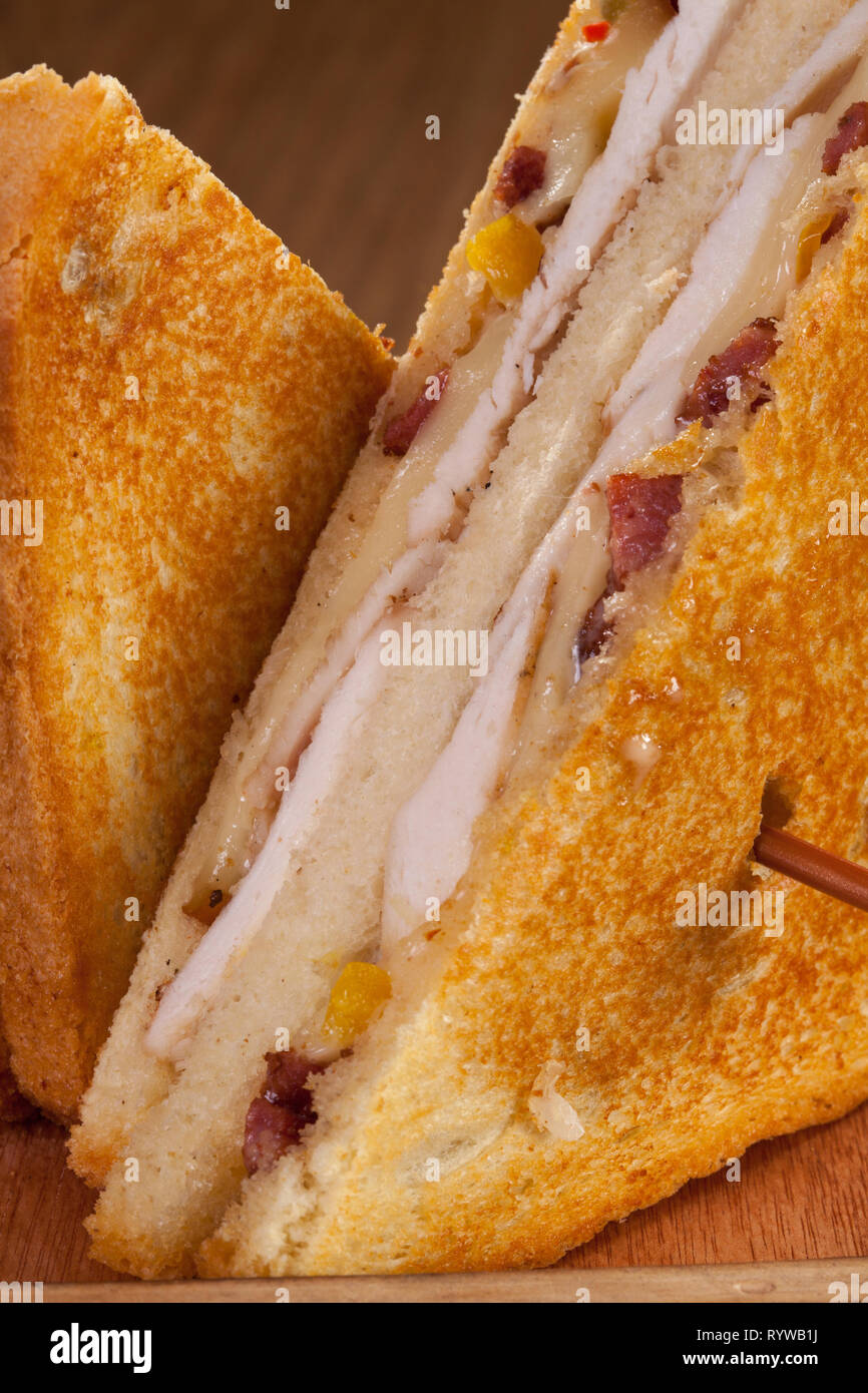 Square toasted bread cut in half stuffed with meat bacon cheese and ...