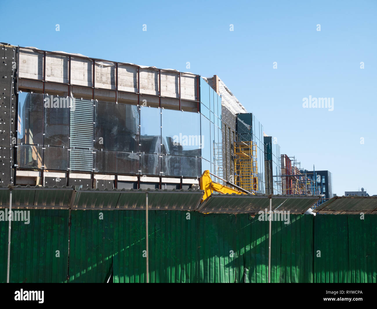 long green fence enclose construction site of small office building ...