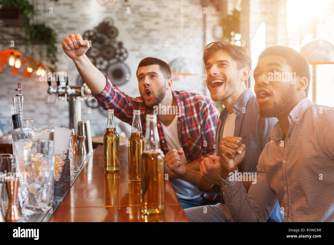 Diverse friends cheering for football team in sport bar Stock Photo - Alamy