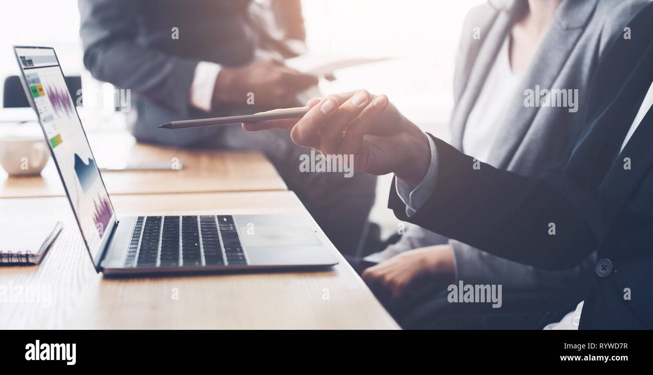 Executives discussing new project on laptop at meeting Stock Photo - Alamy