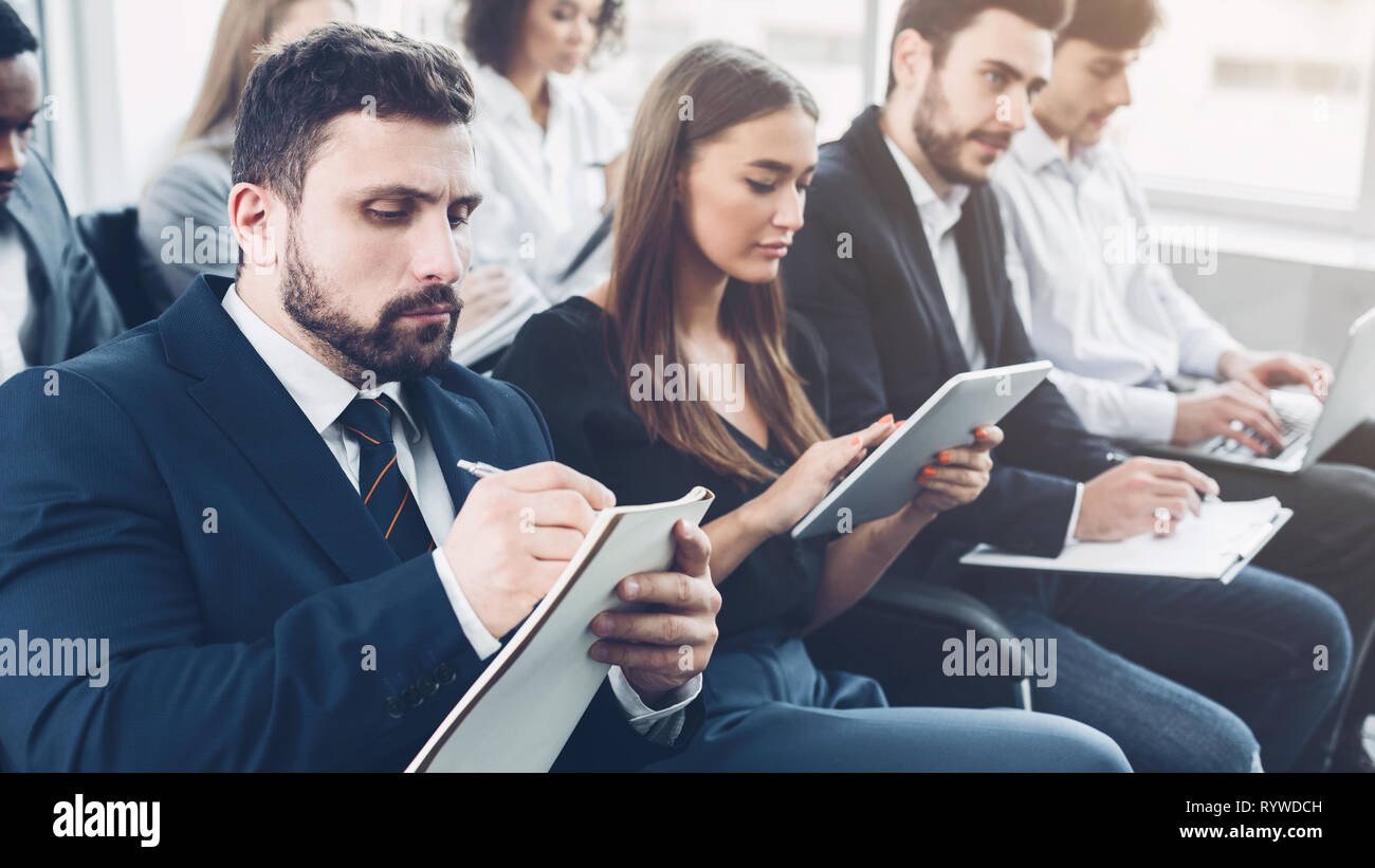 Business people making notes at educational seminar Stock Photo - Alamy