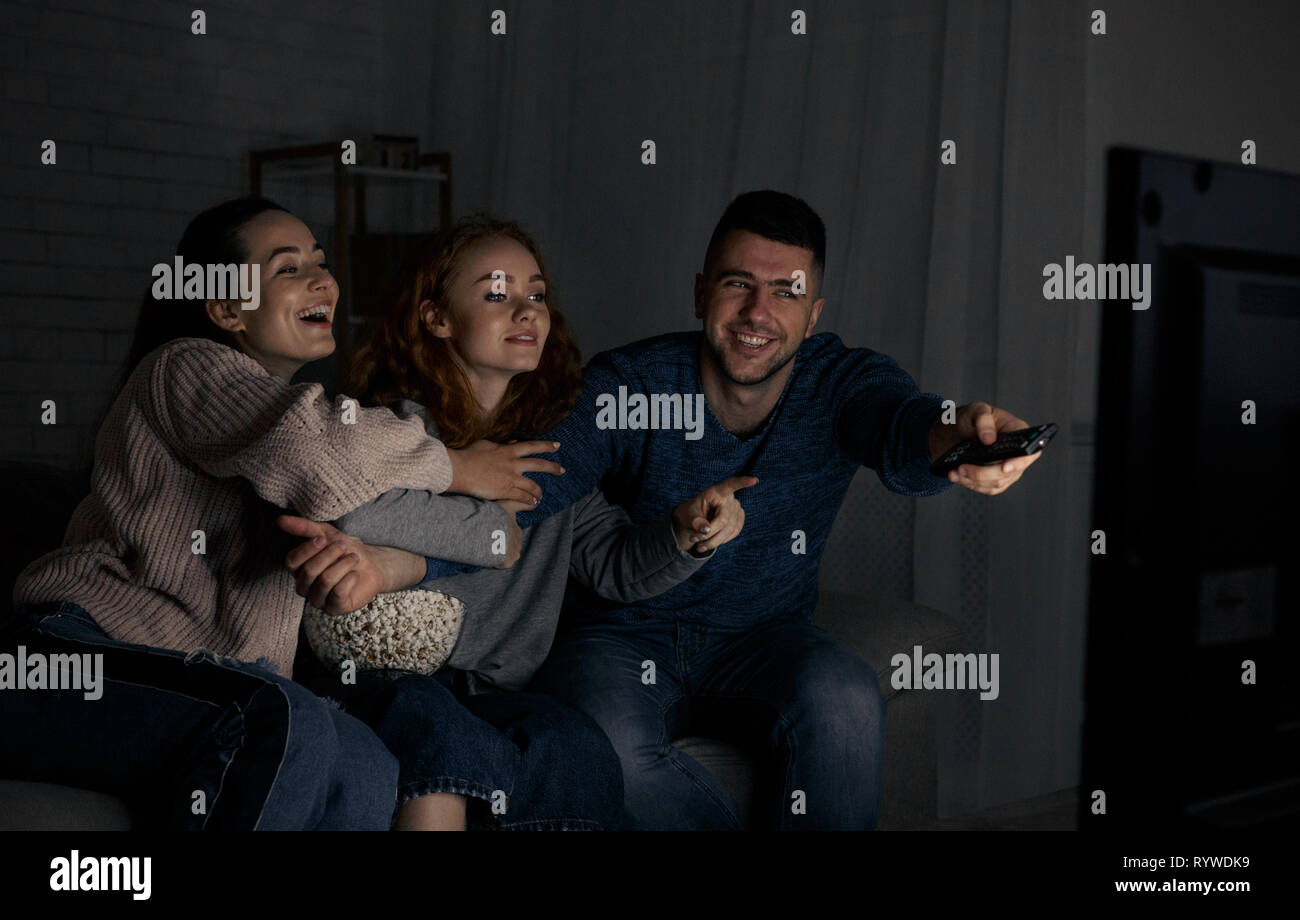 Happy friends watching TV and switching channels Stock Photo - Alamy