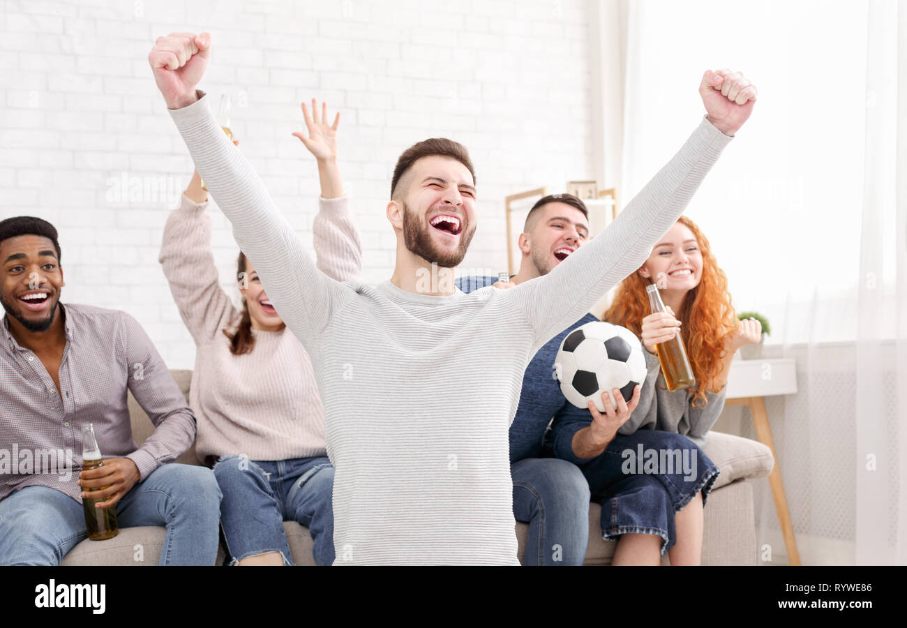 Happy football fans watching soccer on tv Stock Photo - Alamy