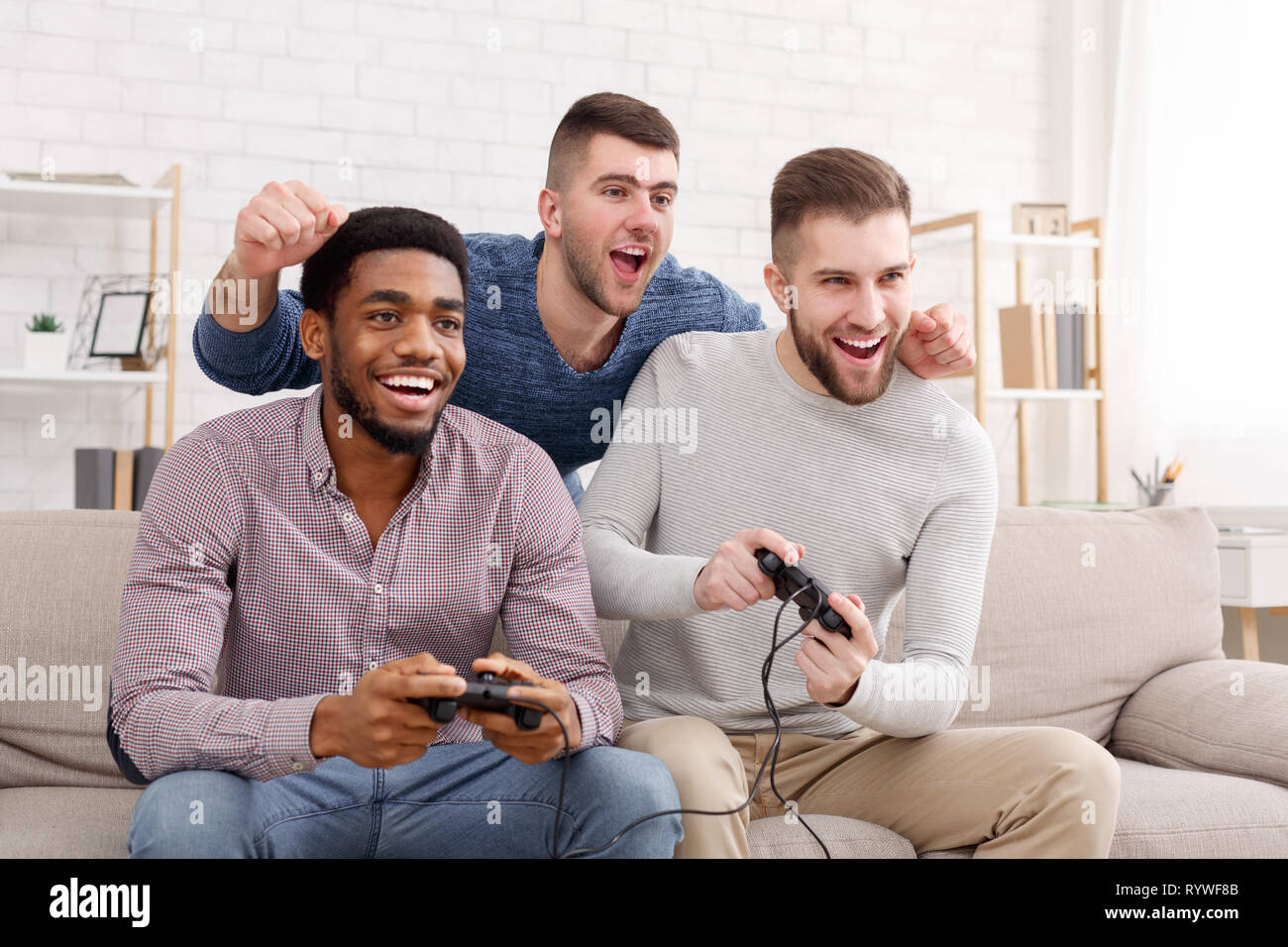 Gamers. Happy men playing video games at home Stock Photo - Alamy