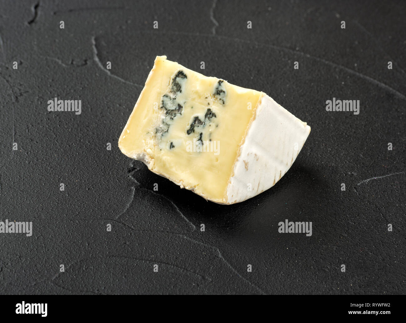 Slice of brie cheese with mold on dark background Stock Photo - Alamy