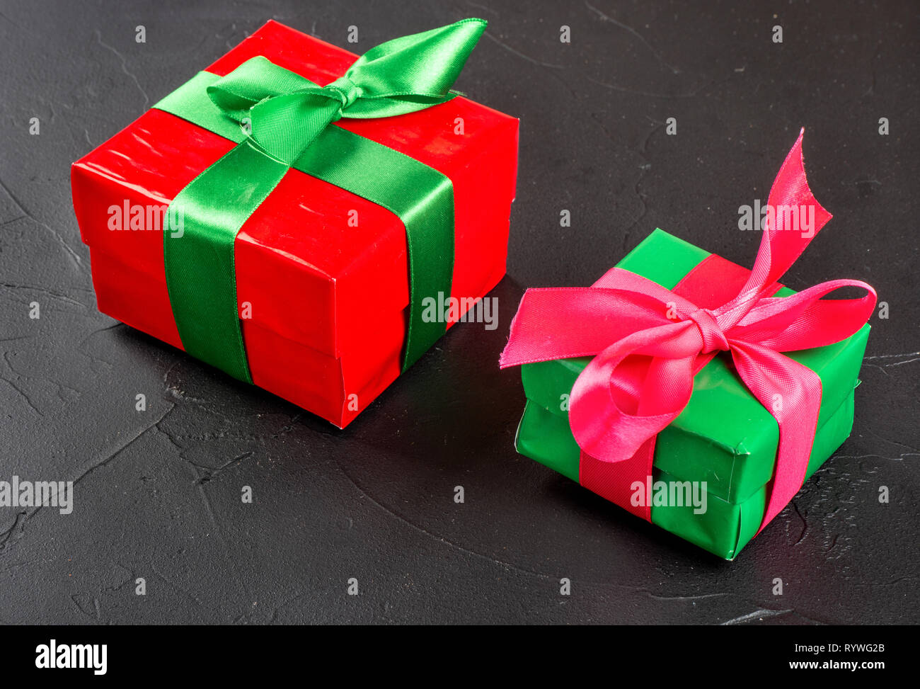 Red and green box with gifts on concrete background Stock Photo - Alamy